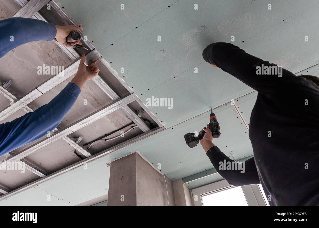 Workers fitting panel into frame of ceiling Stock Photo - Alamy