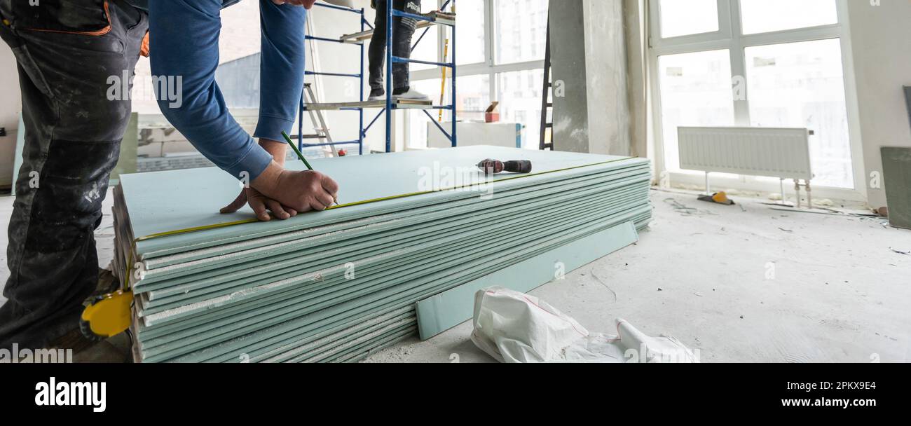 Workers fitting panel into frame of ceiling Stock Photo - Alamy