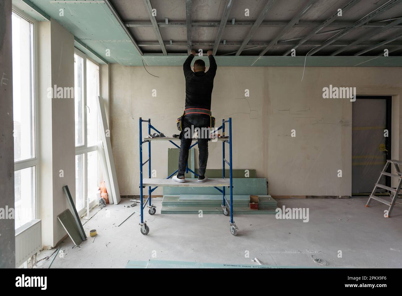 Two man help for ceiling house construction Stock Photo - Alamy