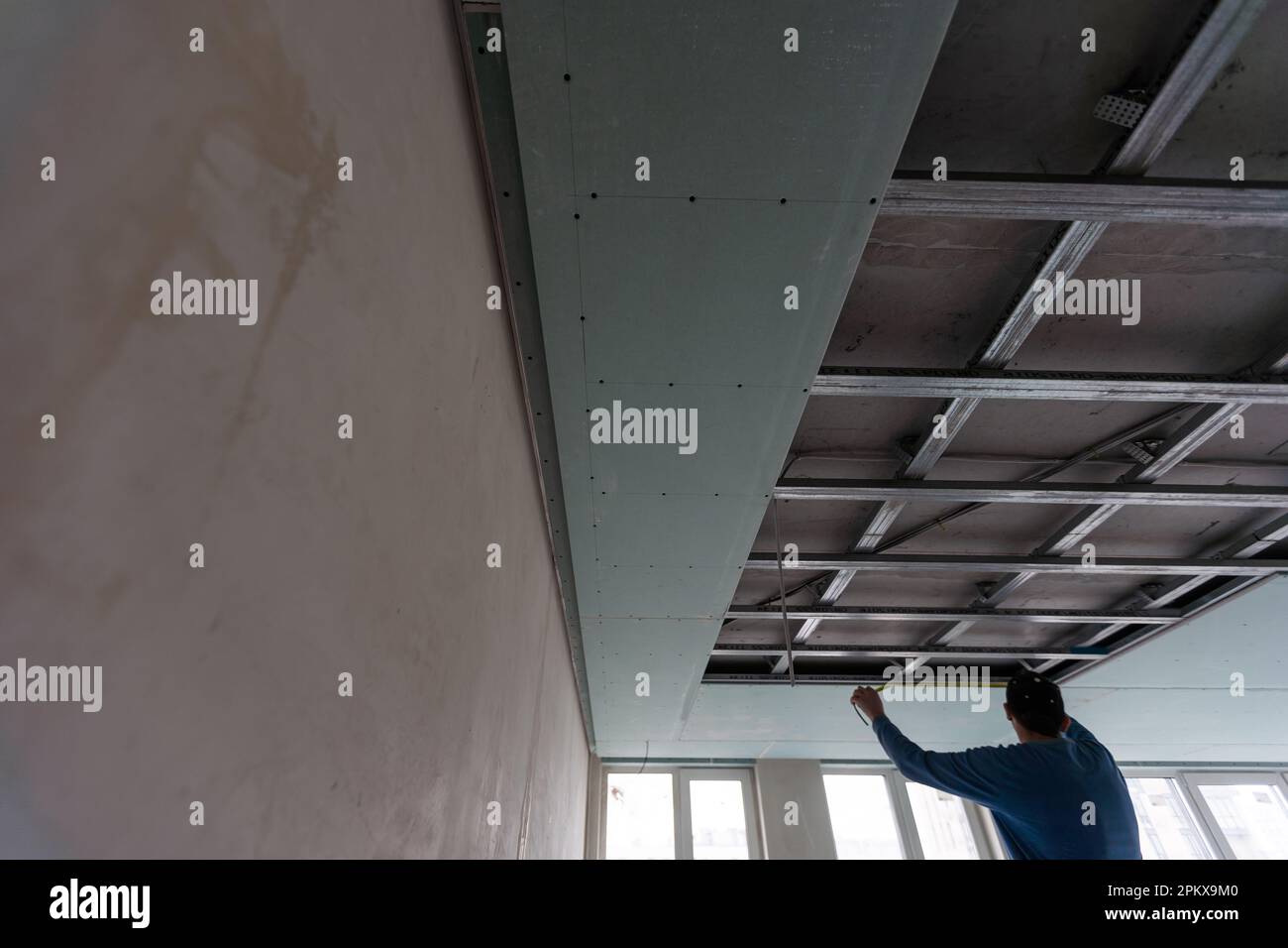 Construction worker, making walls from gypsum plasterboard or drywall ...