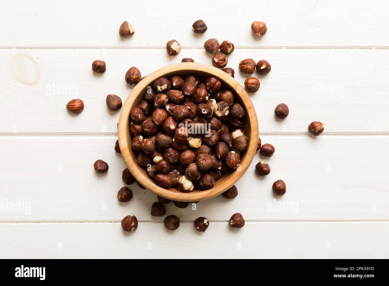 Wooden bowl full of hazelnuts on table background. Healthy eating ...