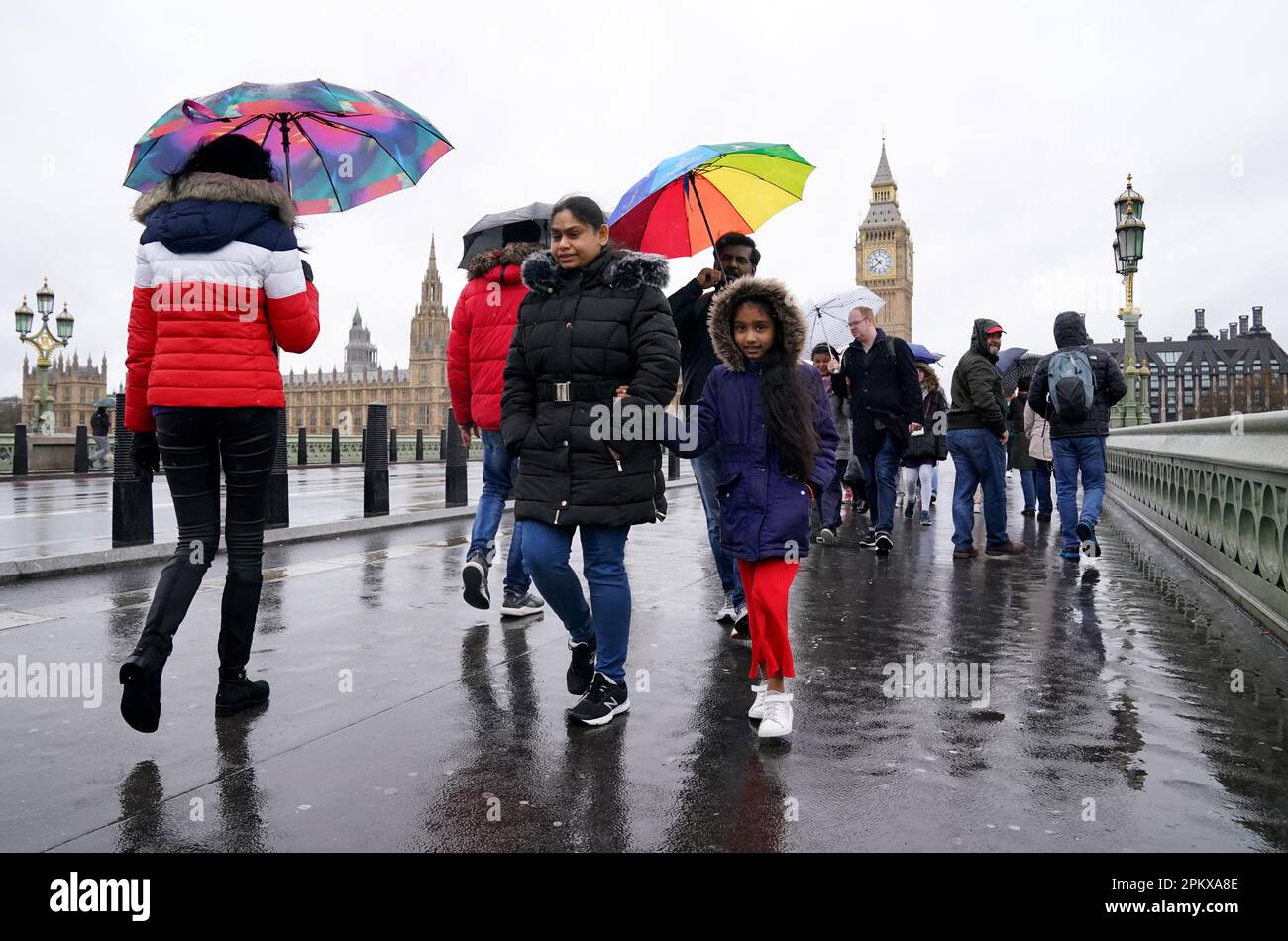 People brave the rainy conditions on Westminister Bridge, London, on ...