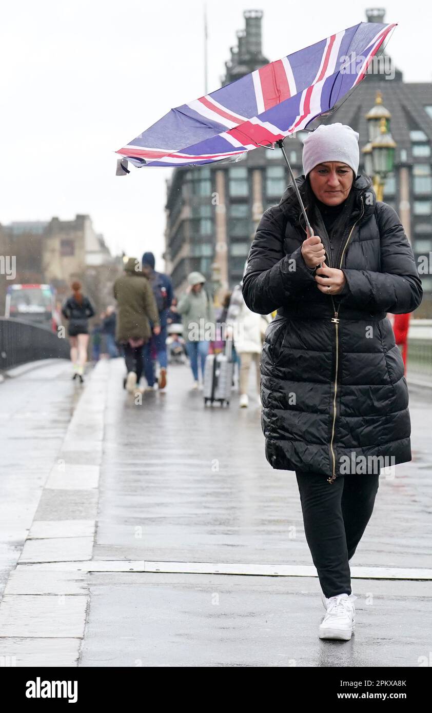 A woman with an umbrella braves the rainy conditions on Westminister ...