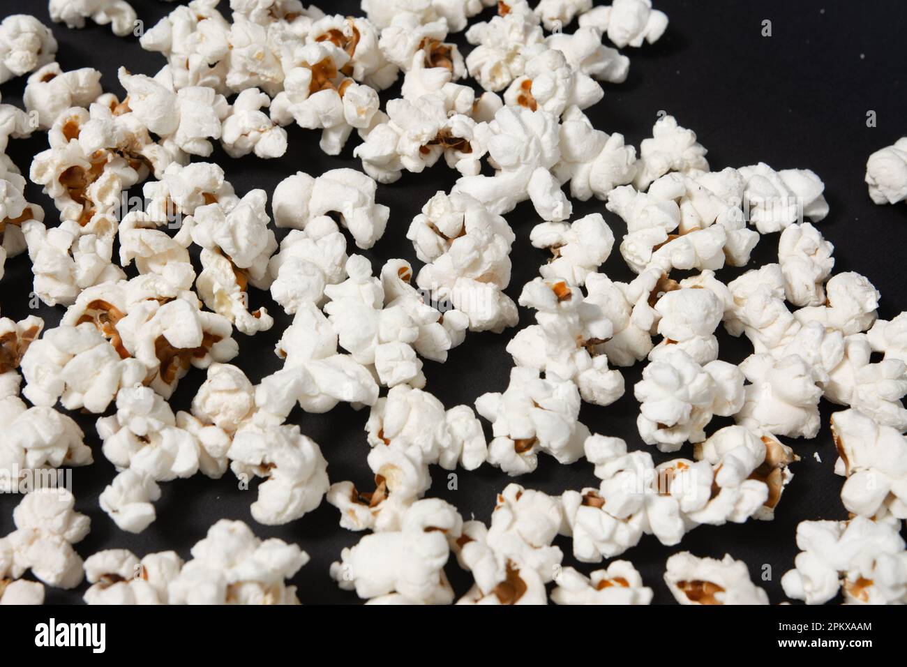 a bowl of freshly cooked popcorn on a black background, popcorn texture ...