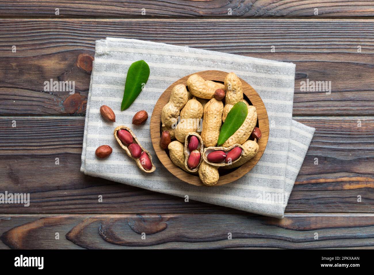 Fresh healthy peanuts in bowl on colored table background. Top view ...