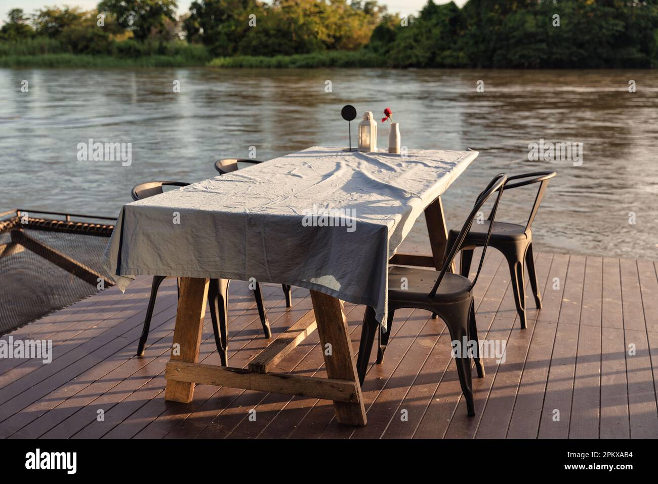 Retro dining table with tablecloth, chair and decorate on wooden raft ...