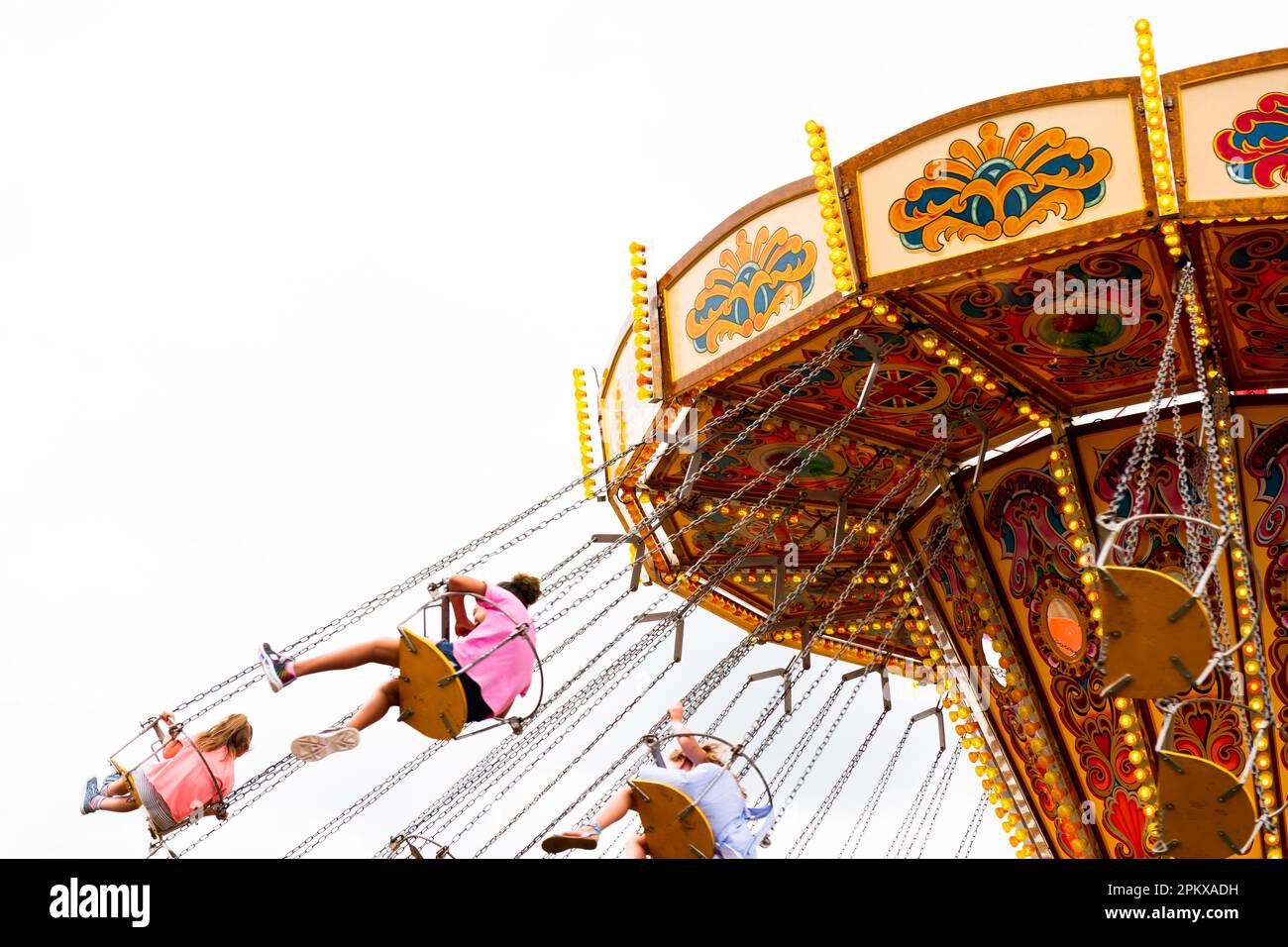 Children enjoying themselves on a vintage 'Flying Chairs' fairground ...