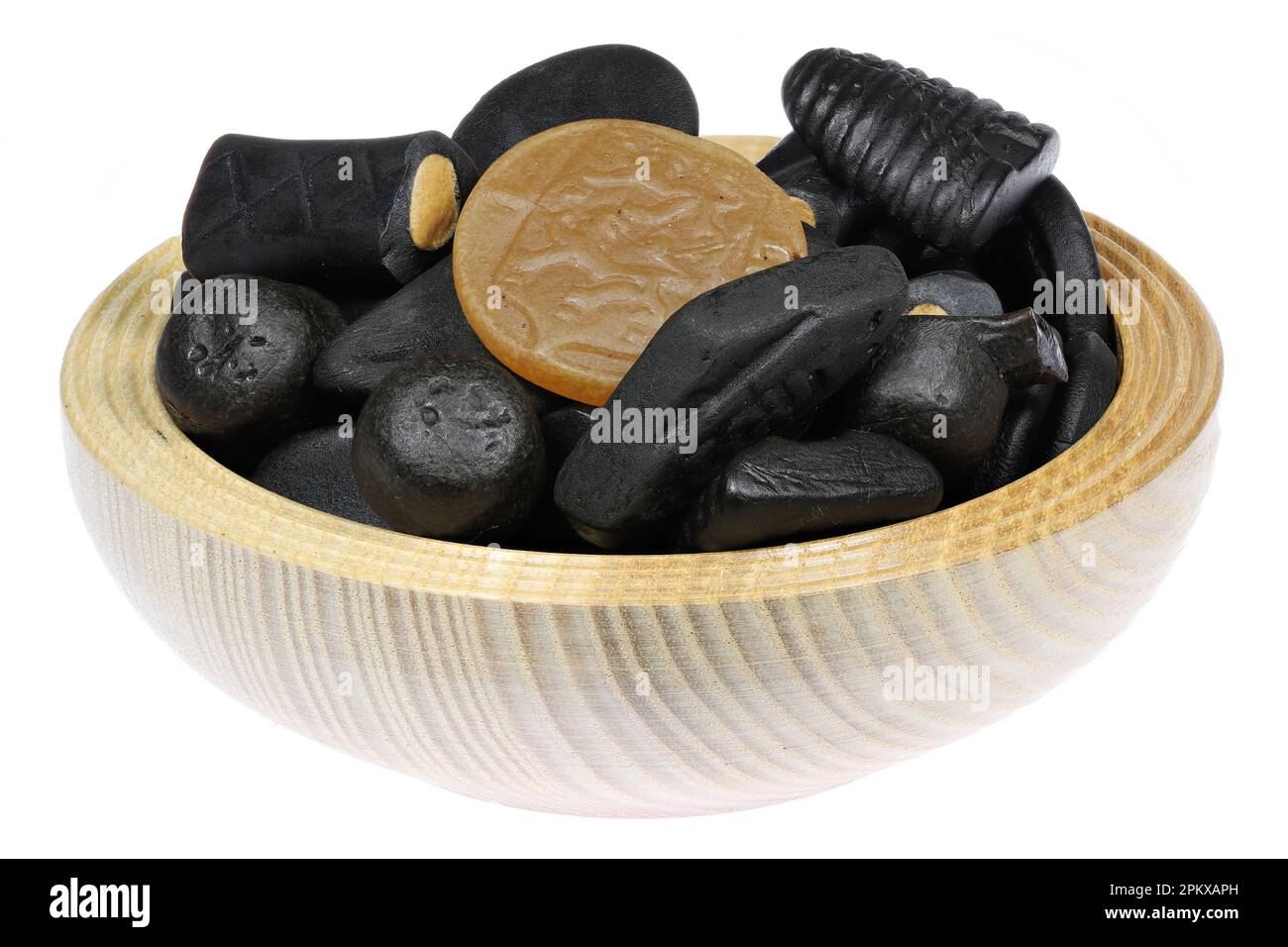 Dutch licorice candies in a wooden bowl isolated on white background ...
