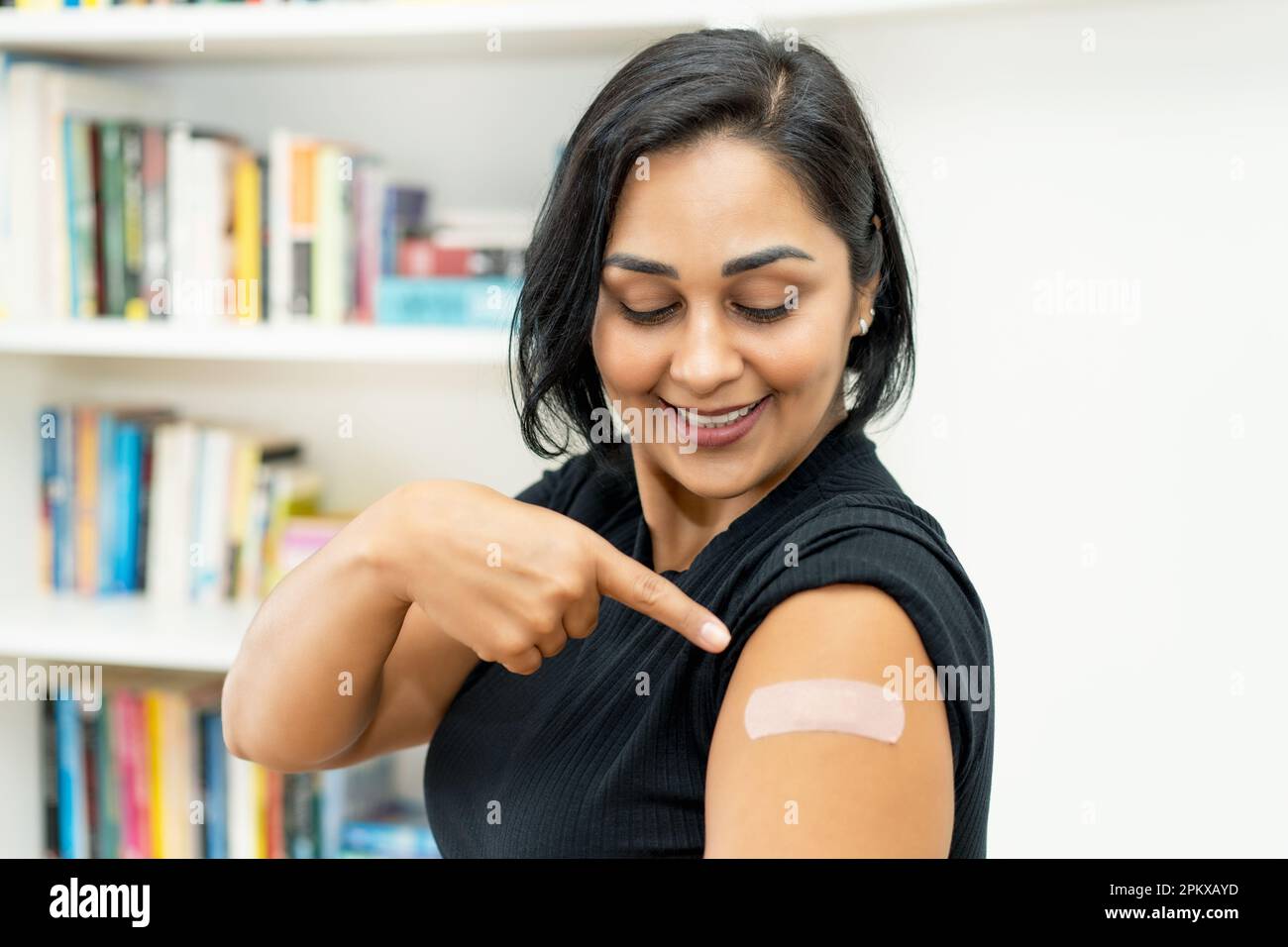 Laughing latin american mature woman with plaster after vaccination at ...