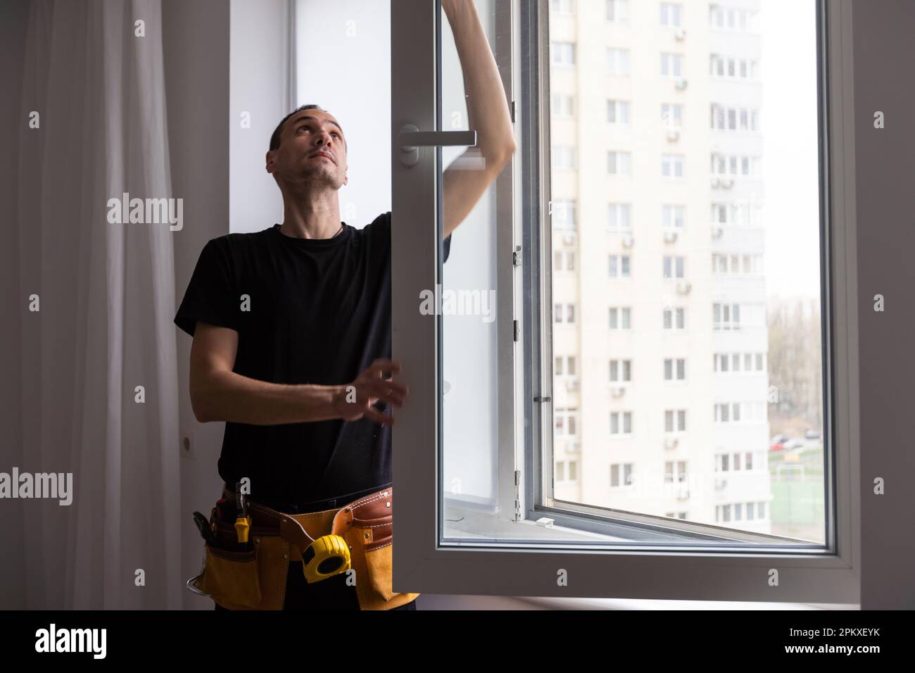 Worker adjusting installed window with screwdriver indoors, closeup ...