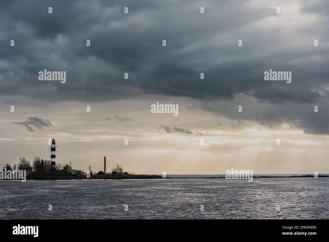 Dramatic landscape with a dark cloudy sky, golden sun rays shining ...