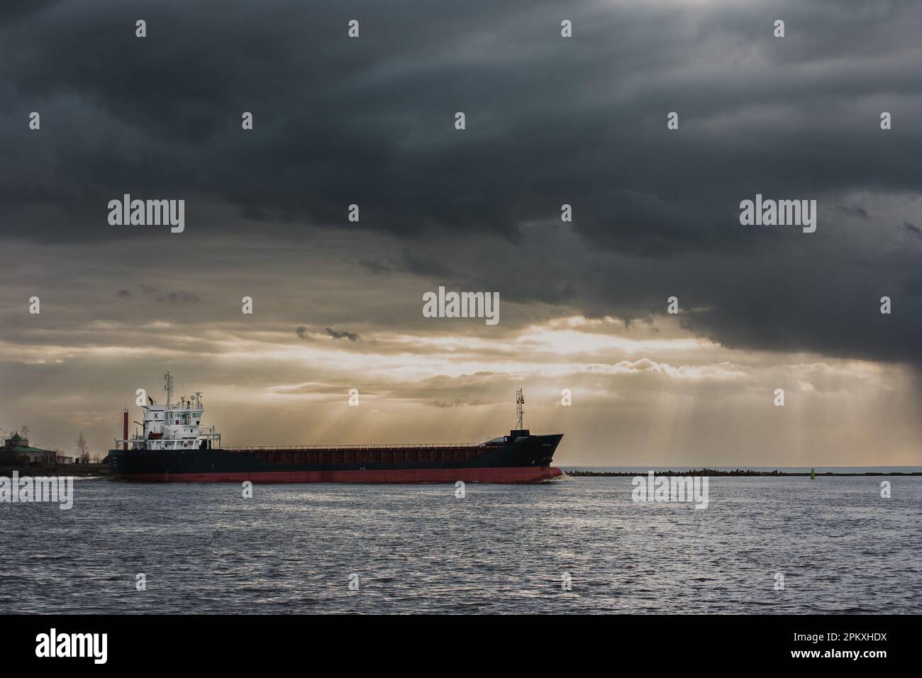 view of a tanker sailing across the sea under a dramatic dark sky with ...