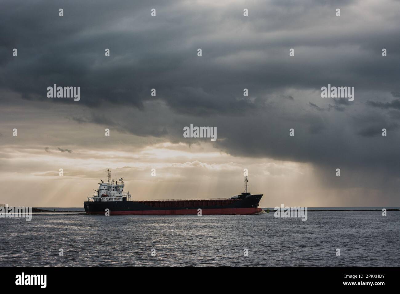 view of a tanker sailing across the sea under a dramatic dark sky with ...