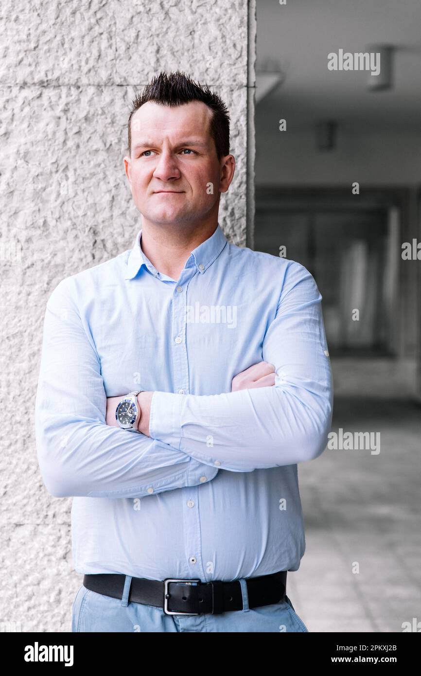 Confident business man standing in the city, looking and dreaming of ...