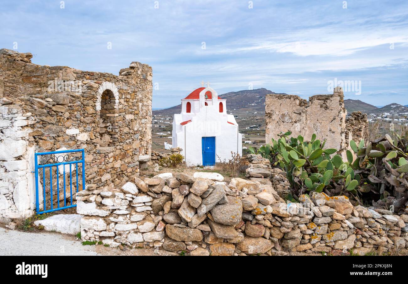 Entrance gate with ruined wall, small Cycladic white and red Orthodox ...