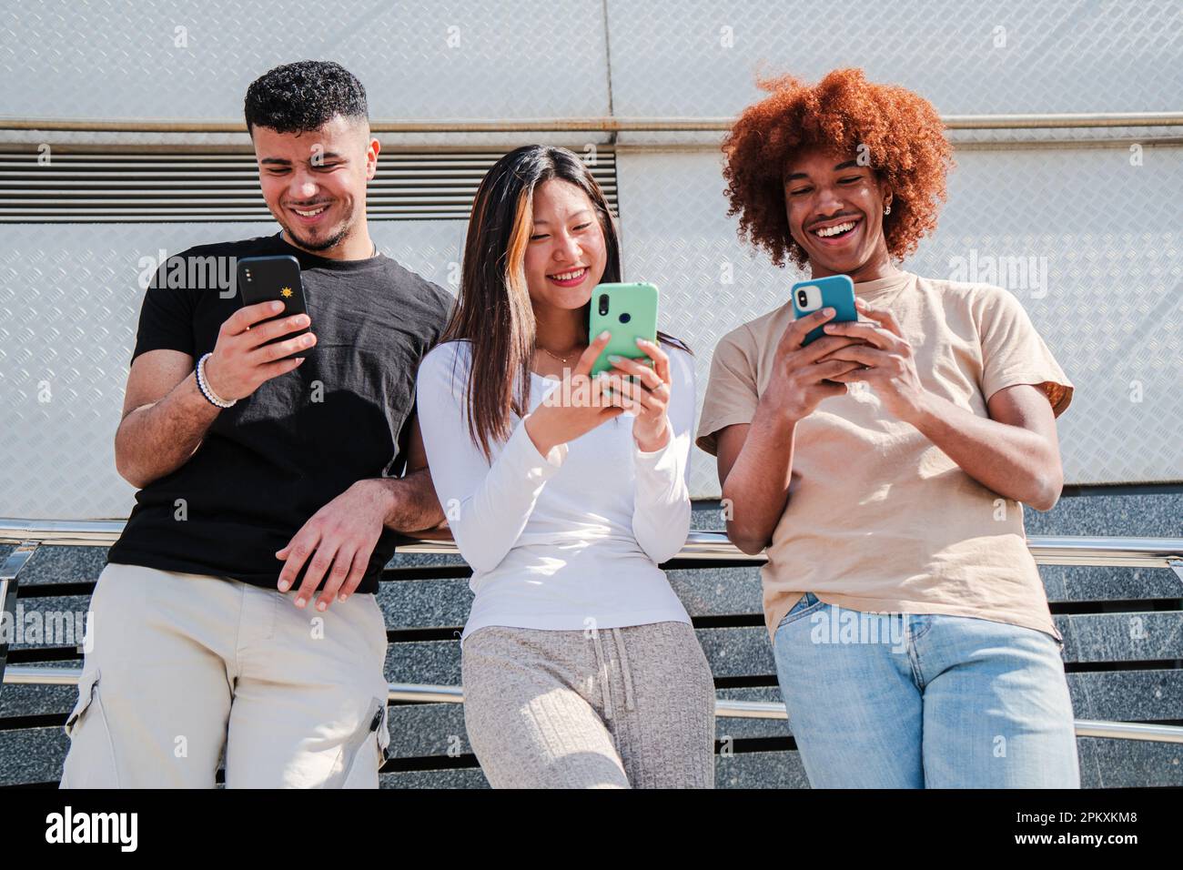 Group of multiracial happy teenagers using a smartphone together to ...