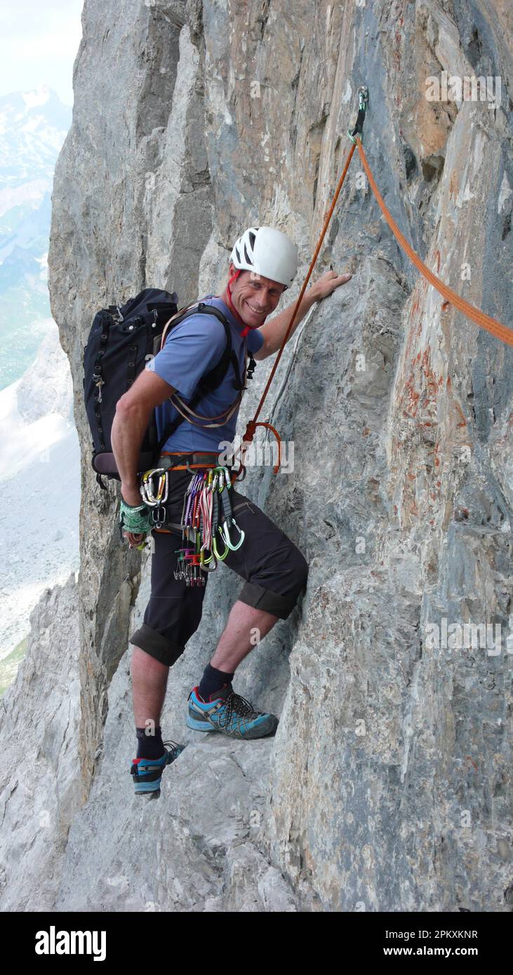Male mountain climber on a steep rock climbing route in the Swiss Alps ...