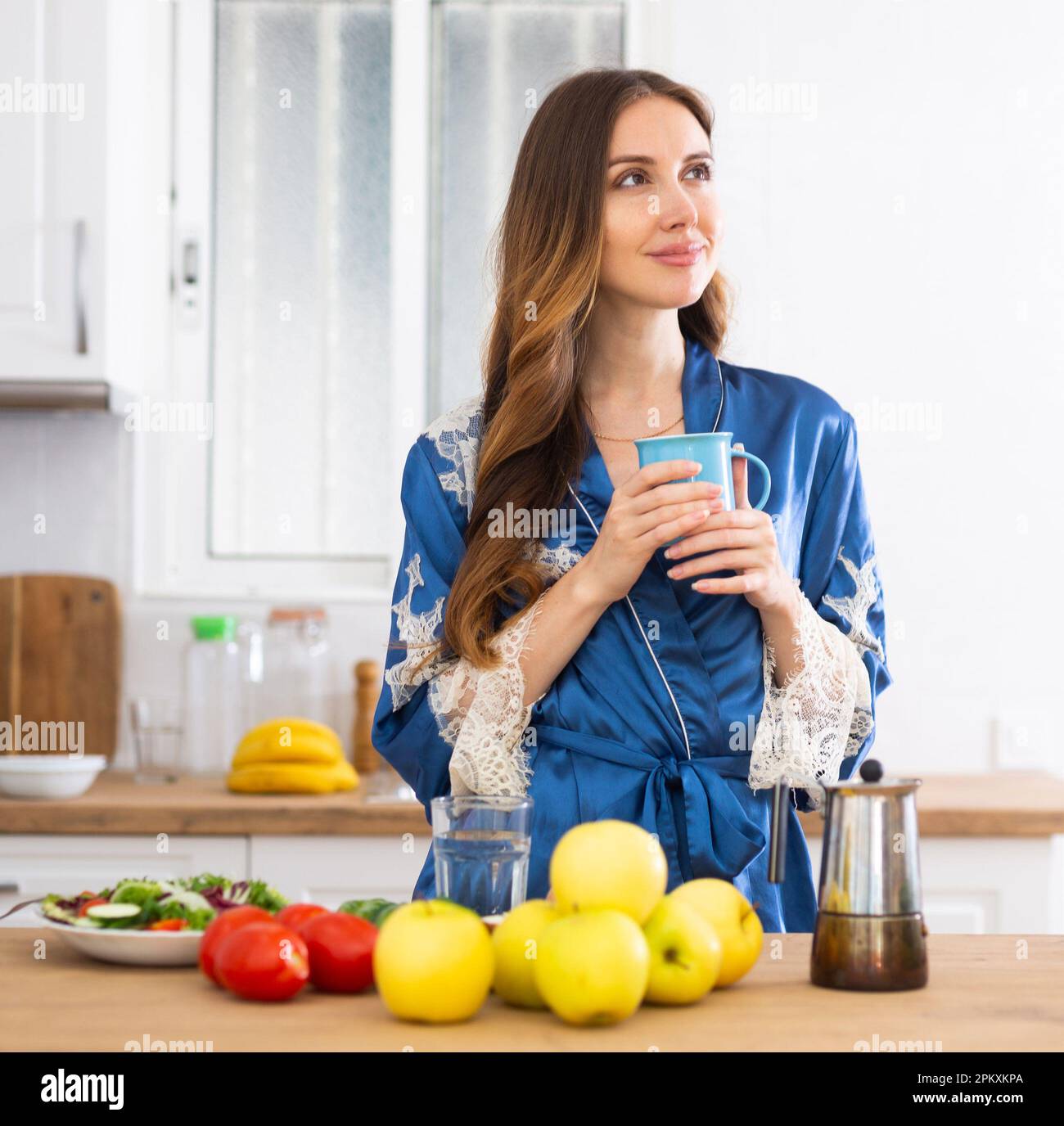 Attractive woman wearing in housecoat making coffee at kitchen Stock ...