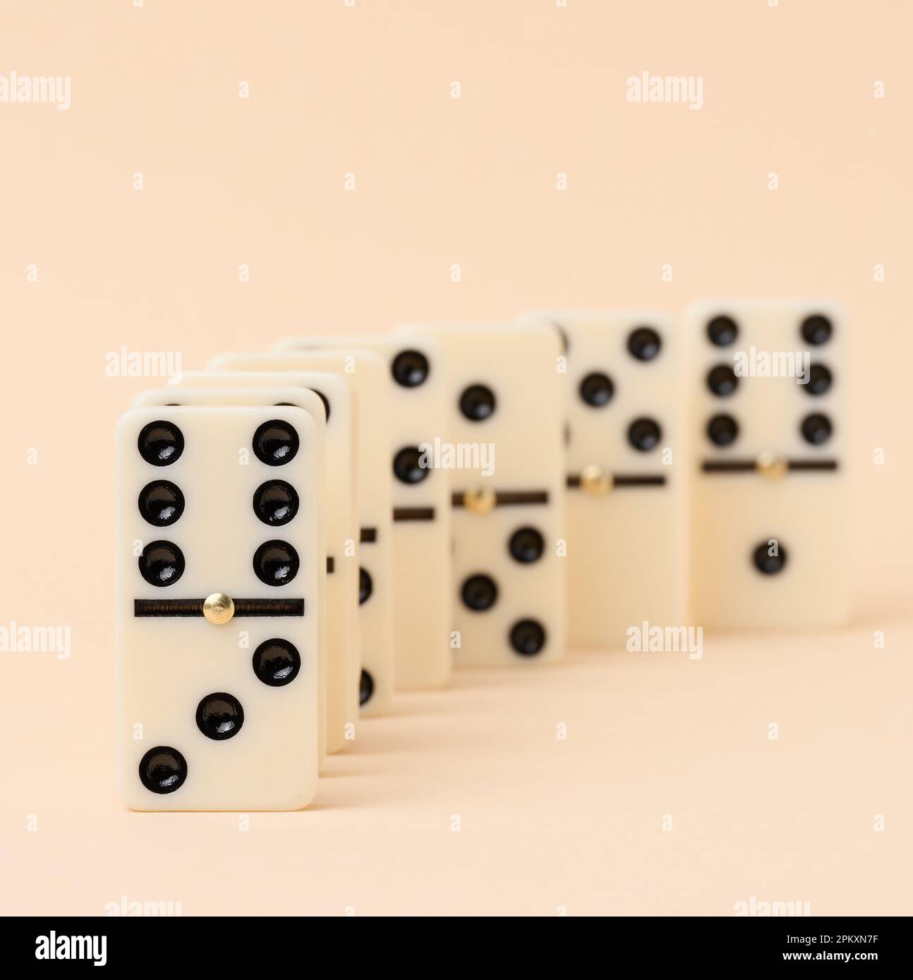 A stack of dominoes on a beige background, an intellectual game Stock ...