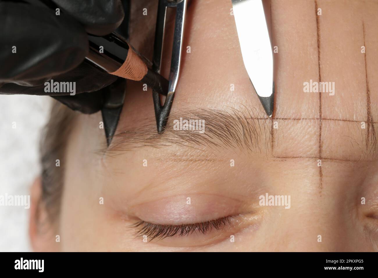 Mikrobleiding eyebrow measurement. Cosmetologist makes markings with ...