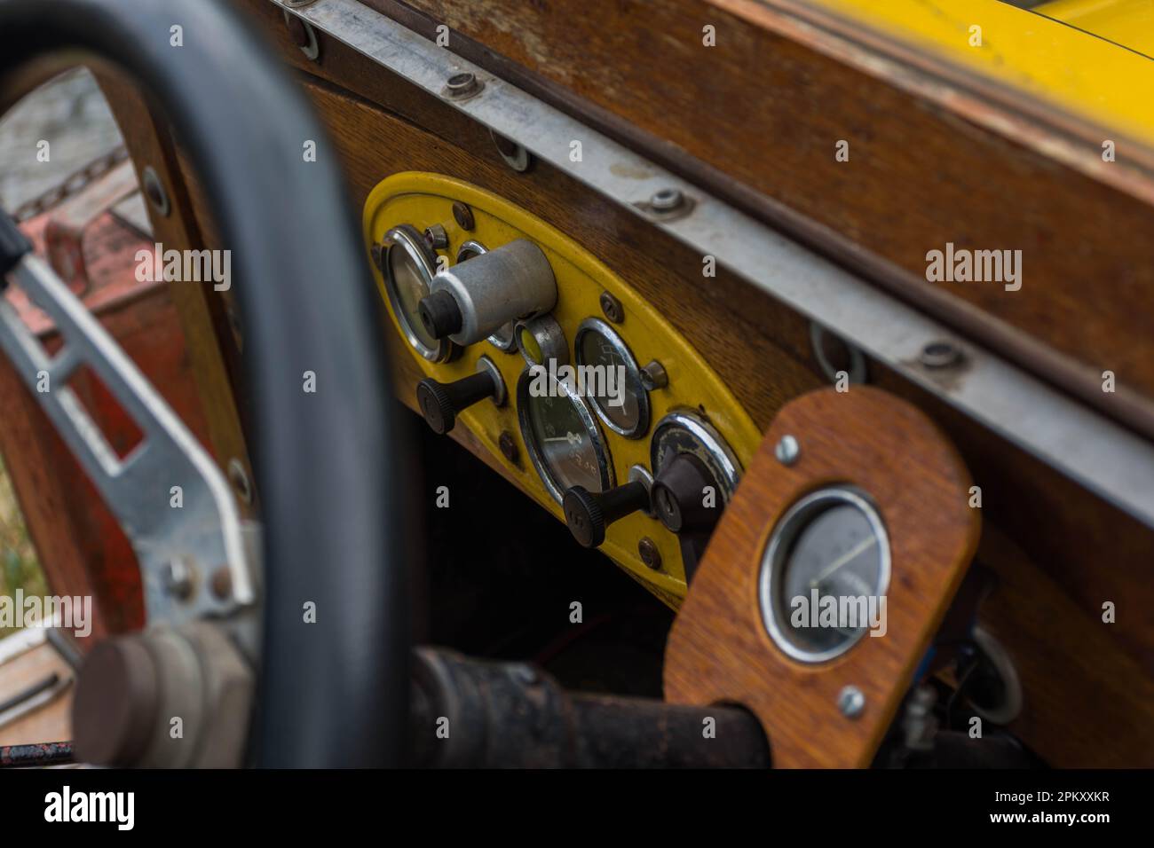 A detailed close-up of an antique ship's wheel, with its polished brass ...