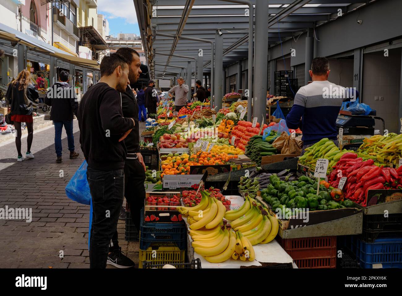 Young men buying from Fruit and vegetable market stall in downtown ...
