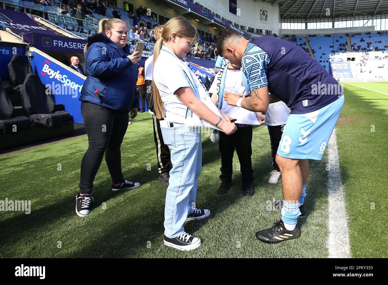Coventry City's Gustavo Hamer (right) signs a young mascots shirt ...