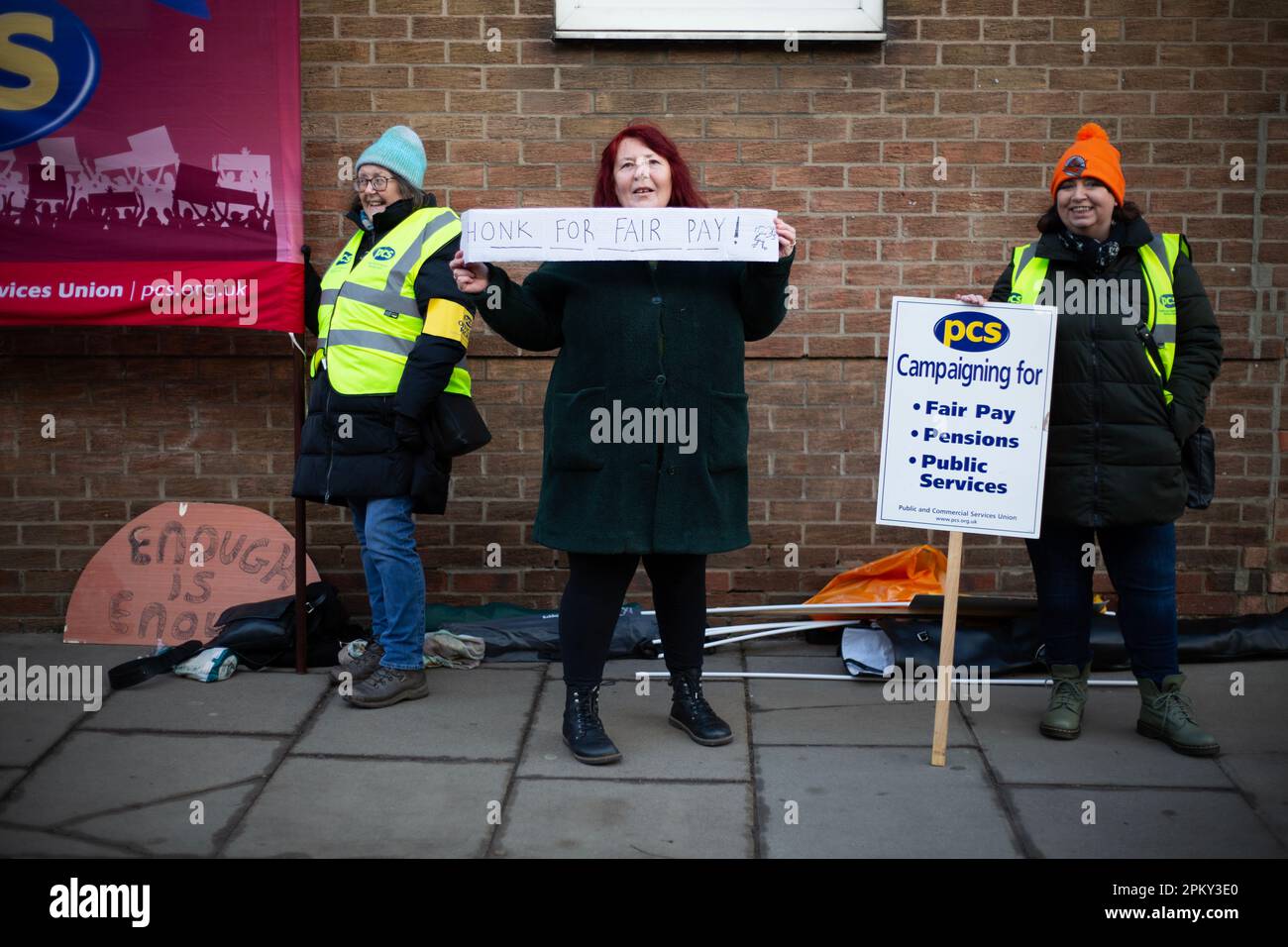 A civil servant worker holds a 'Honk for Fair Pay' sign at an official ...