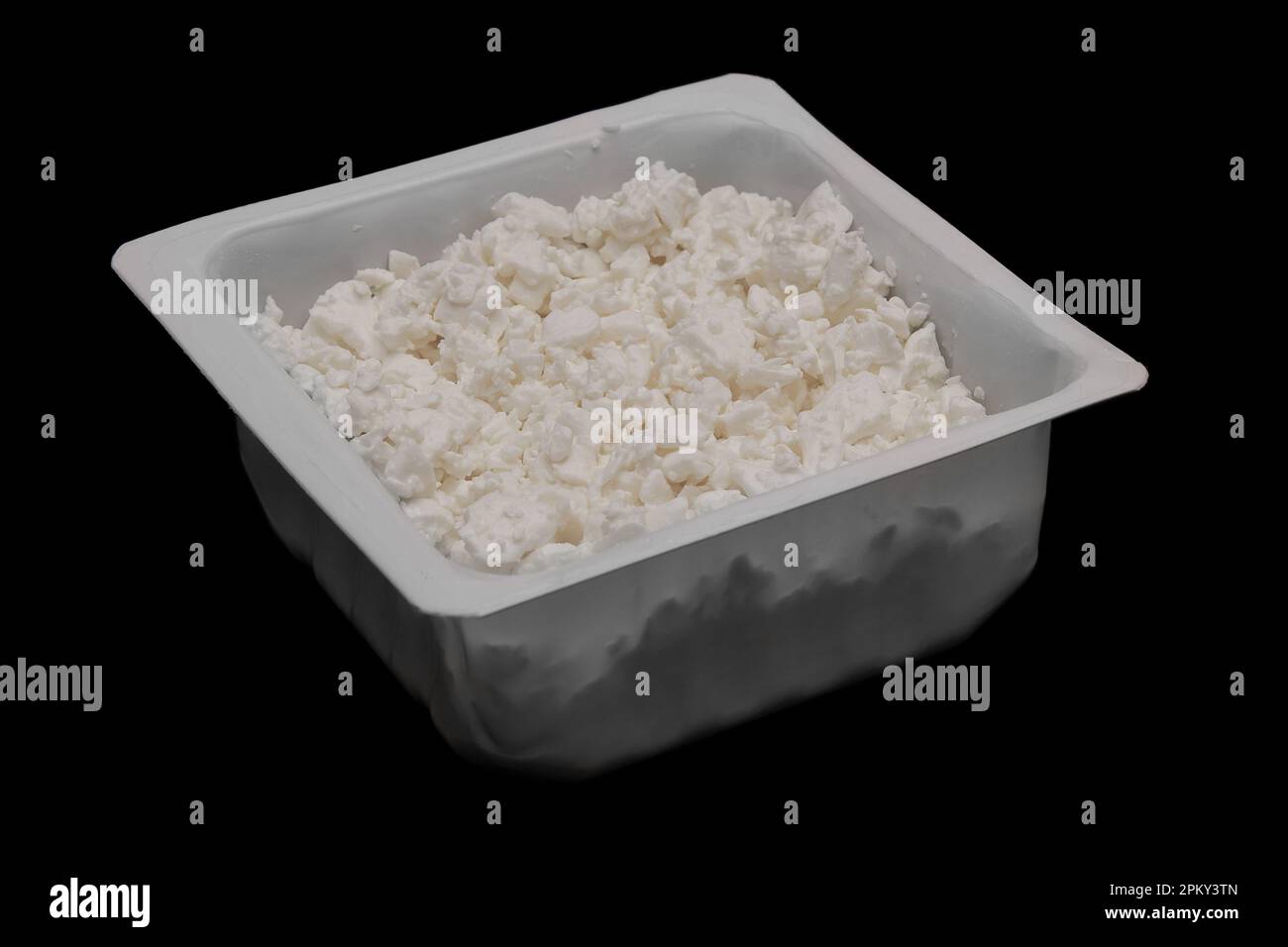 Cottage cheese in container isolated on black background. Nutty ...
