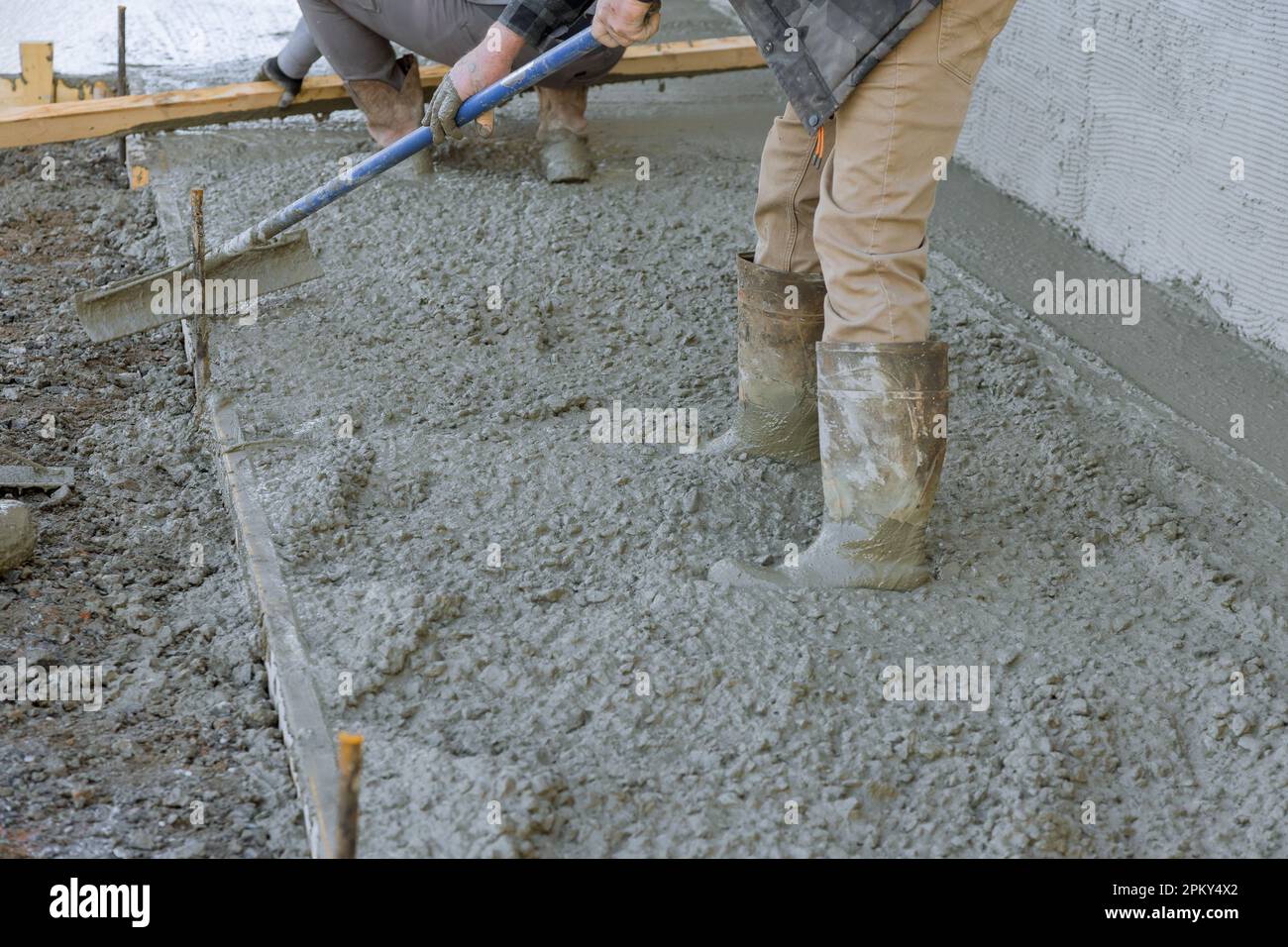 After pouring concrete employee used long trowels to level sidewalk ...