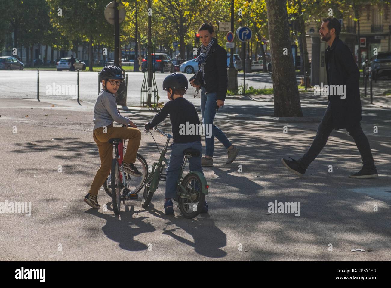Boys wearing helmets enjoying bicycle ride together on a sunny day in ...