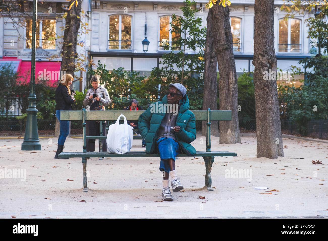 An older man enjoys a quiet moment on a garden bench, taking a break ...