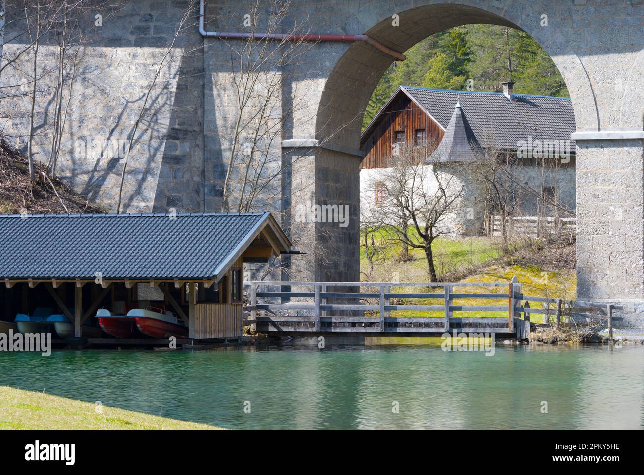 clear reflecting mountain lake with wooden bridge boathouse pedal boats ...