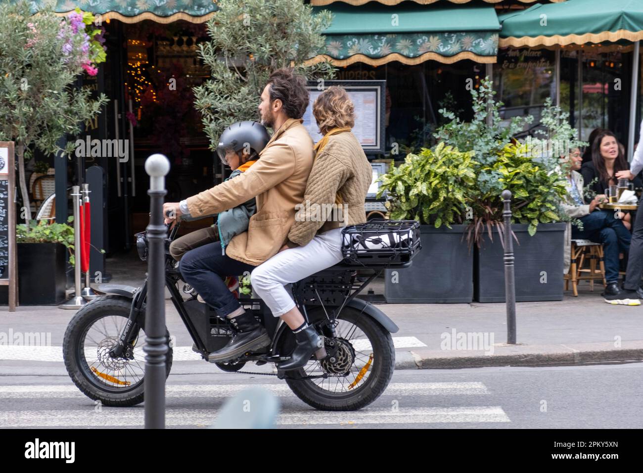 Father, Mother, and Son Riding a vintage Motorcycle Through the Streets ...