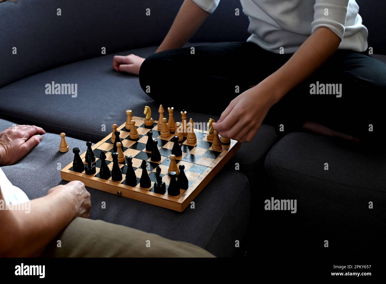 Grandmother playing chess with her granddaughter at home. Strategy and ...