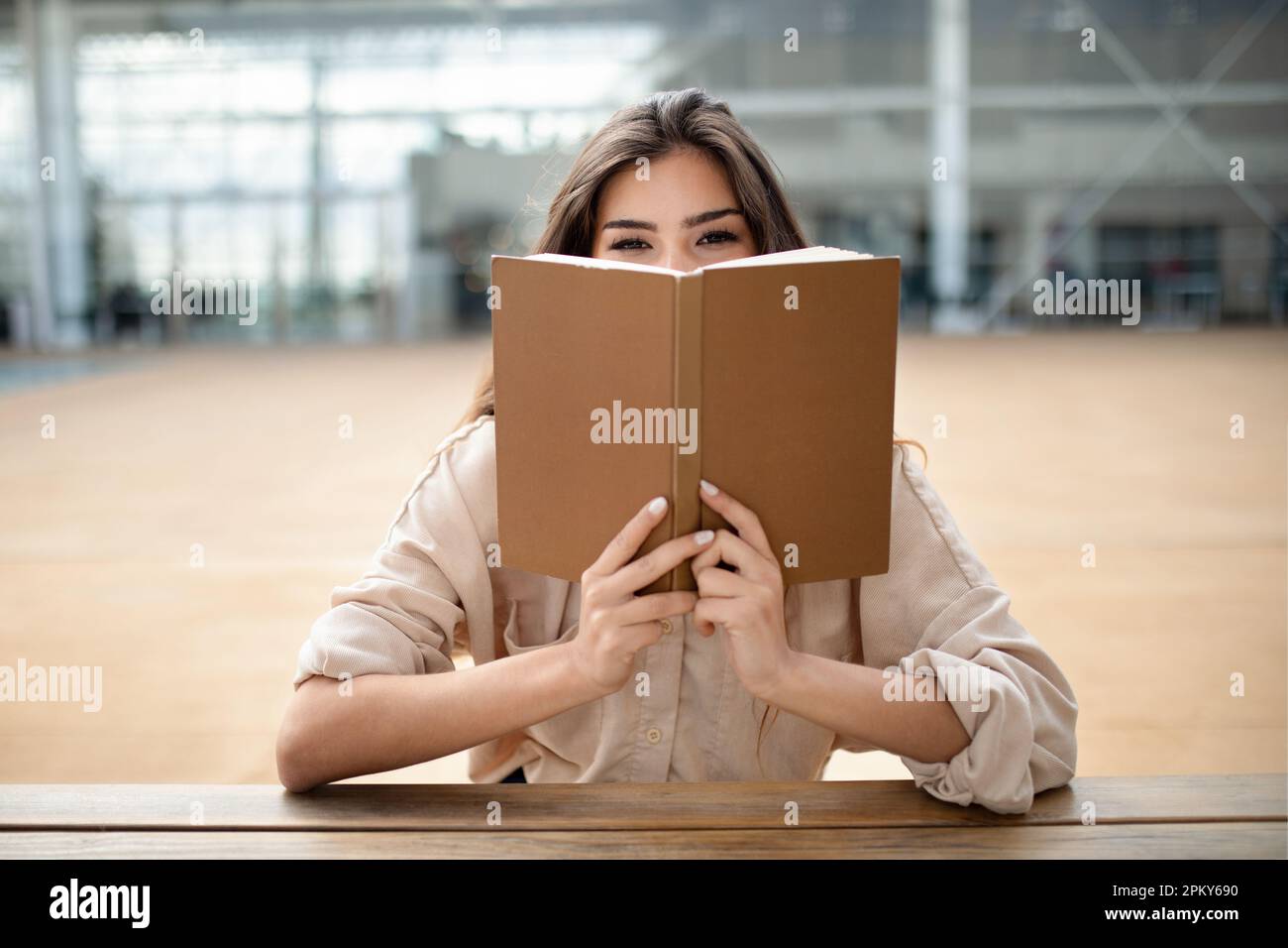 Funny smiling millennial caucasian lady brunette student reads book in ...