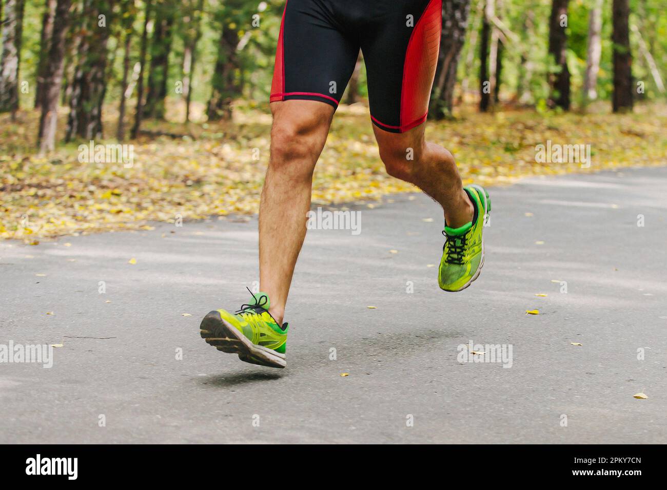 legs male runner running on road in city park race, autumn marathon ...