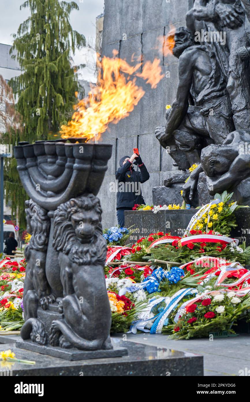 Menorah with burning flame in front of the Warsaw Ghetto Heroes ...
