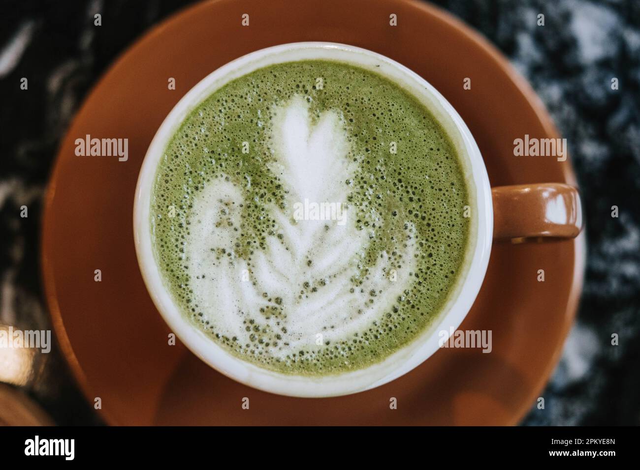 Flat lay or top view shot of a cup of Matcha Latte with beautiful Latte ...