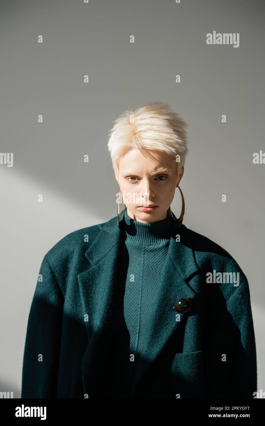 young albino woman with fair-skin posing in green dress and coat on ...