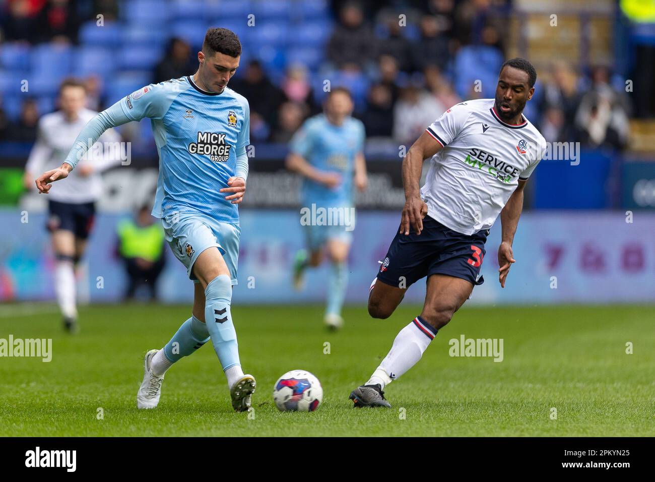 Lloyd Jones #6 of Cambridge United is closed down by Cameron Jerome #35 ...