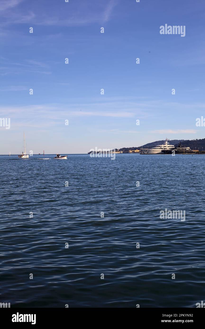 Sea and a cliff in a bay seen from the distance at sunset Stock Photo ...