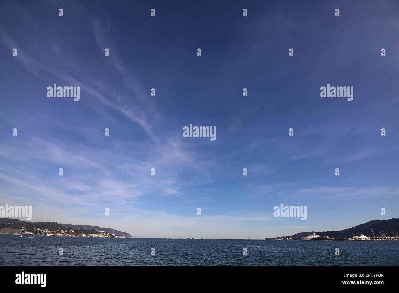 Sea and a cliff in a bay seen from the distance at sunset Stock Photo ...