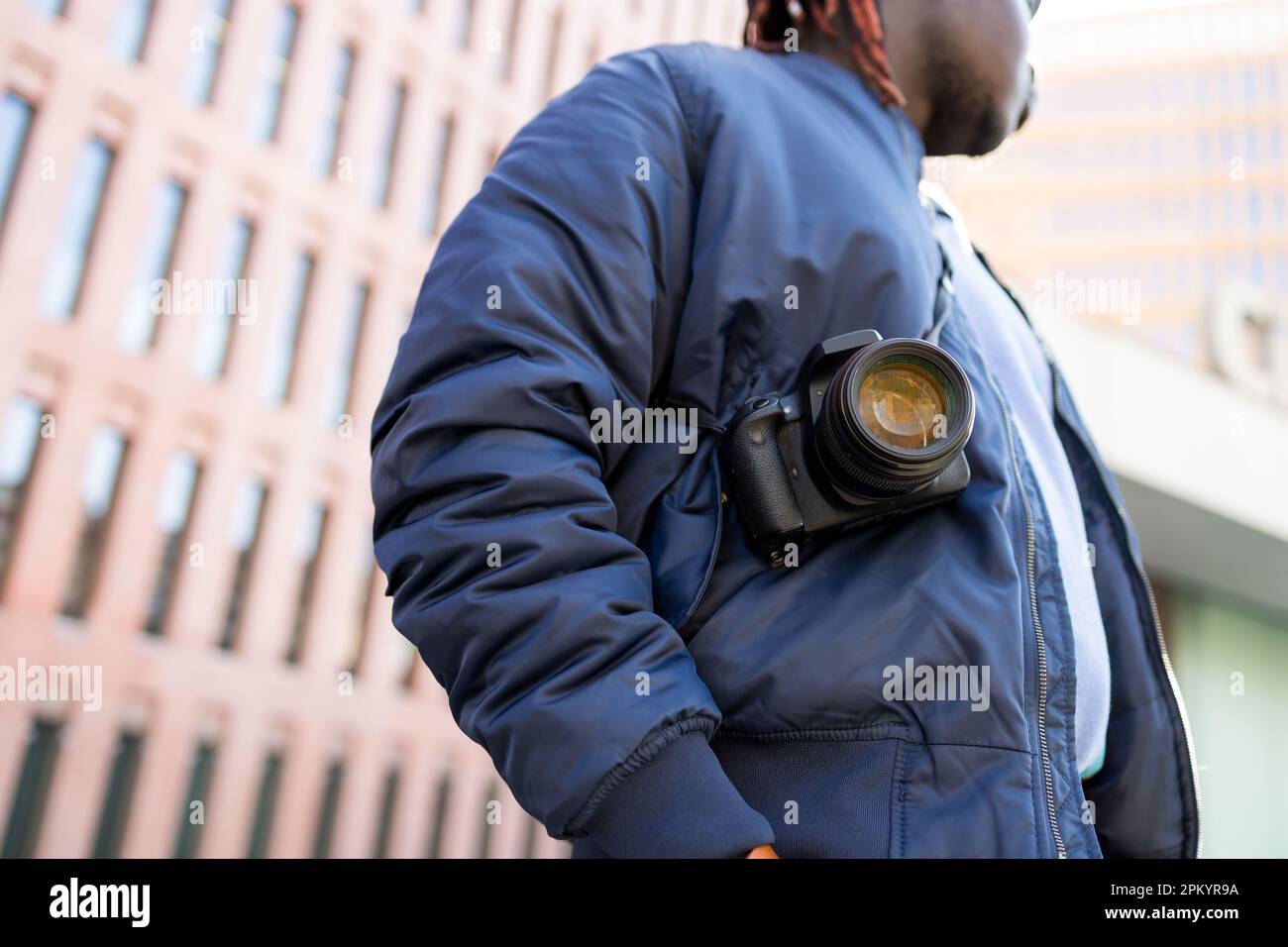 Low angle of black male photographer with professional photo camera ...