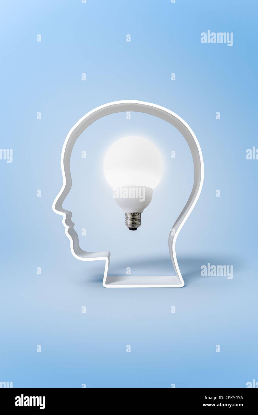 Glowing round bulb placed in white shaped human head isolated on blue ...