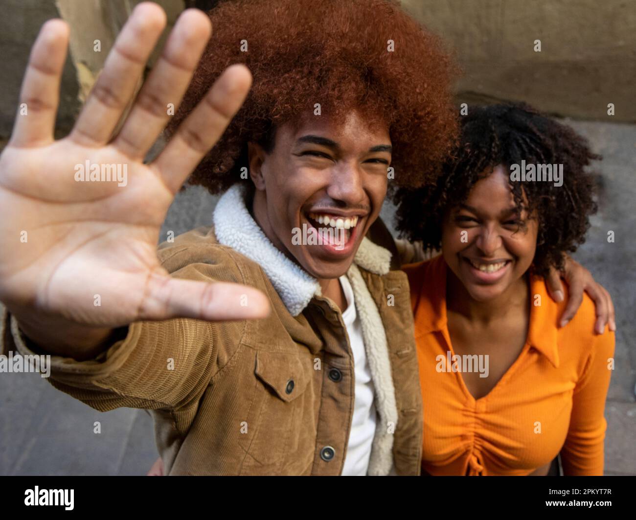 From above of cheerful African American male hugging cool black ...