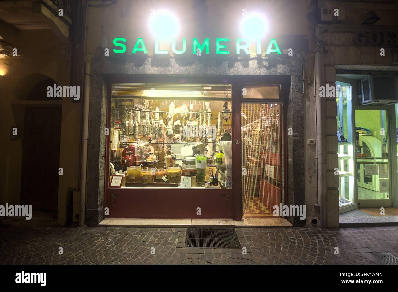 Historical food shop in a cobbled alley of an italian town at night ...