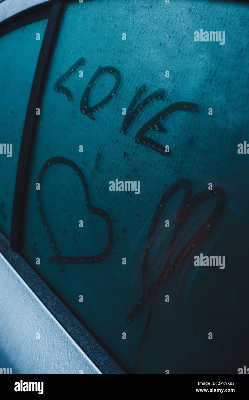 Love inscription and heart symbol on fogging up automobile window in ...