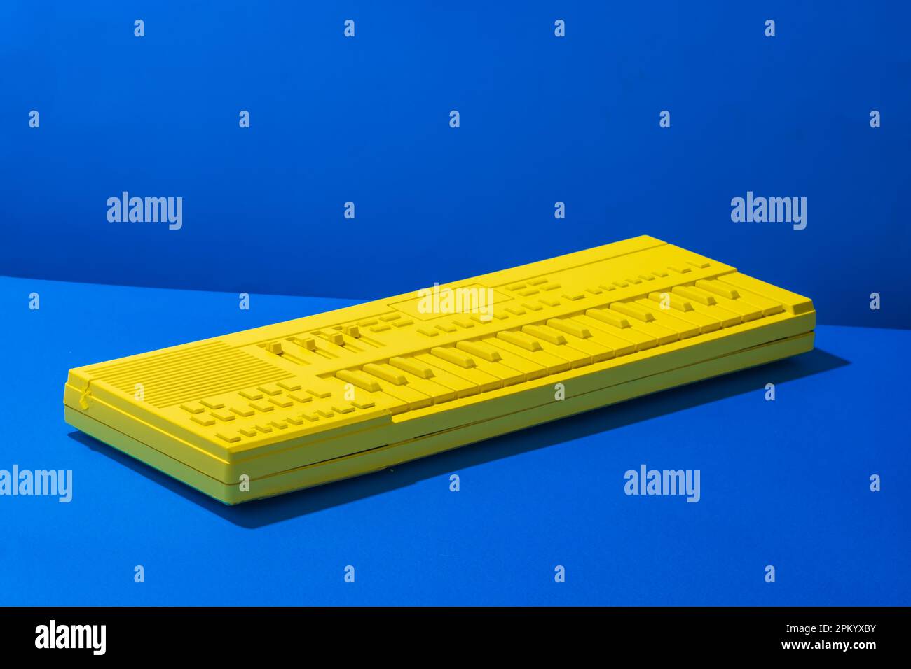 Total yellow synthesizer keyboard with keys and buttons placed on blue ...