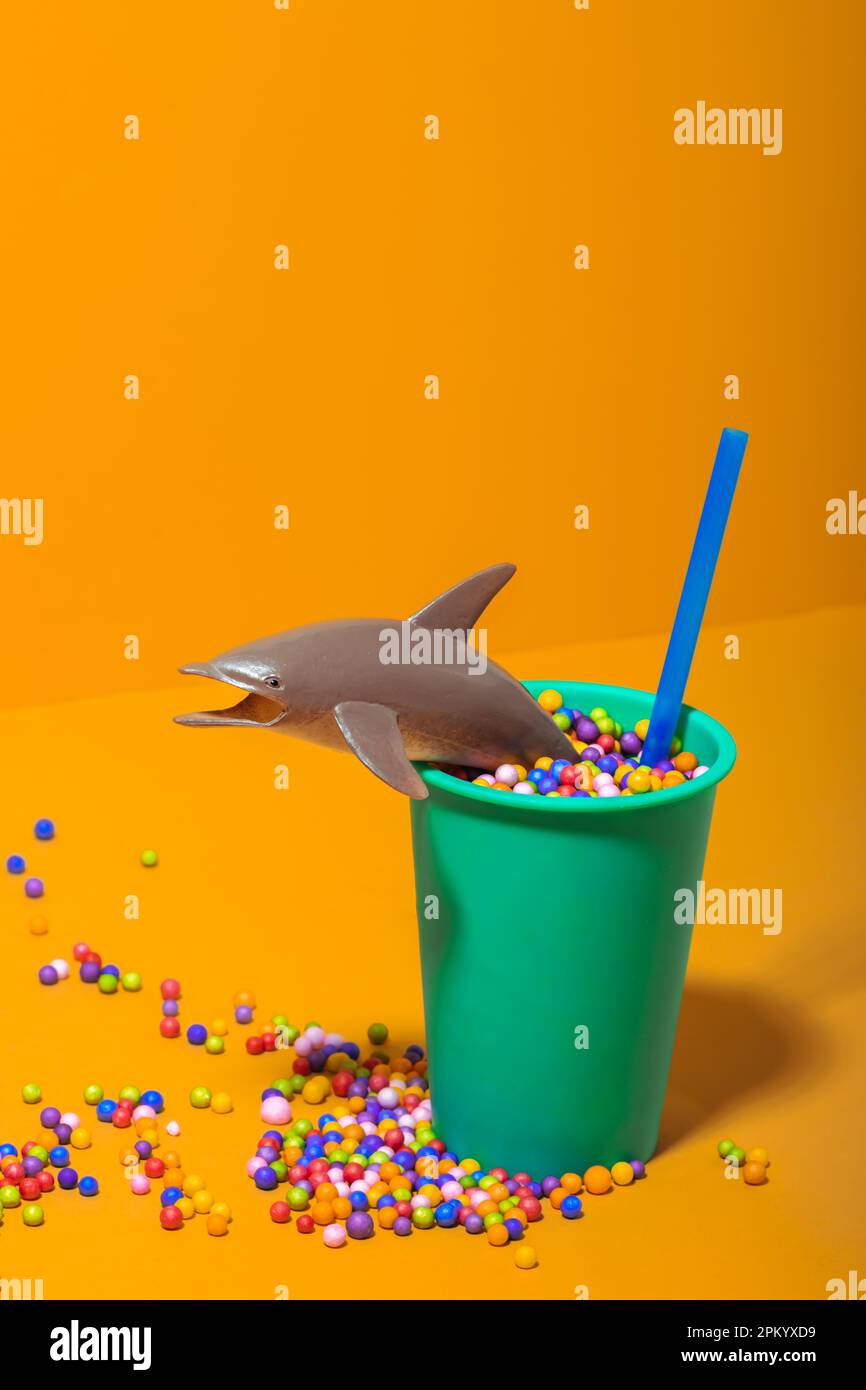 Gray dolphin figurine placed in green bucket with multicolored bright ...